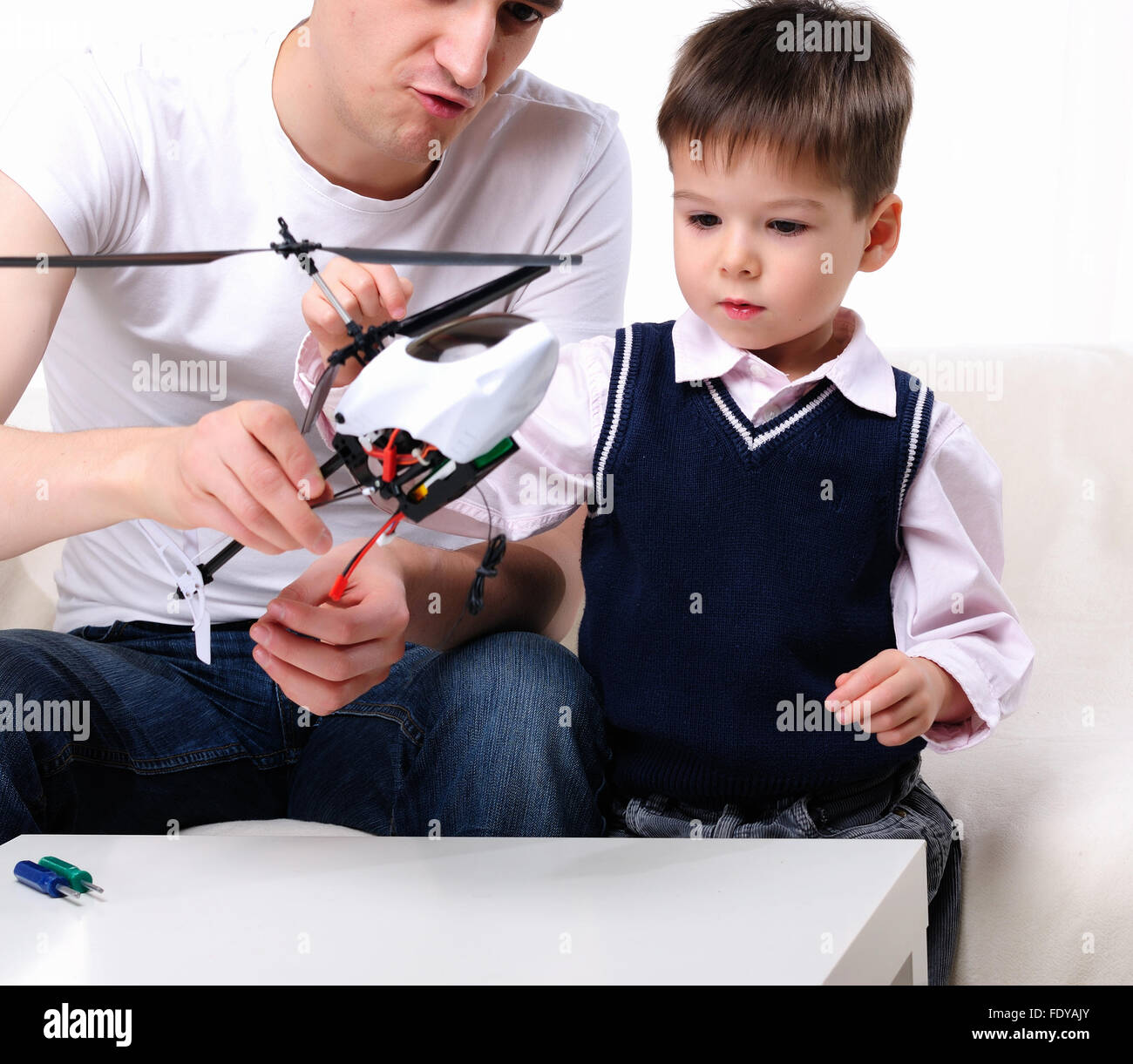 Father and his young son together renovating a small helicopter Stock ...