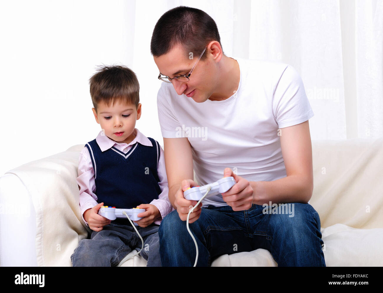 A young father and son together playing video games Stock Photo - Alamy