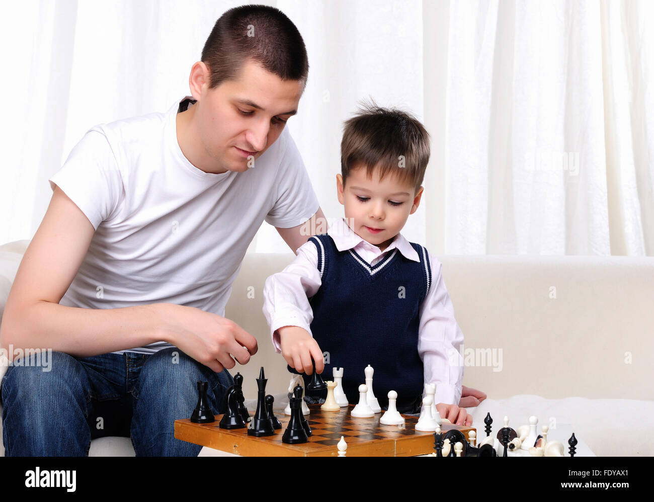 Dad and son playing chess at the table Stock Photo - Alamy