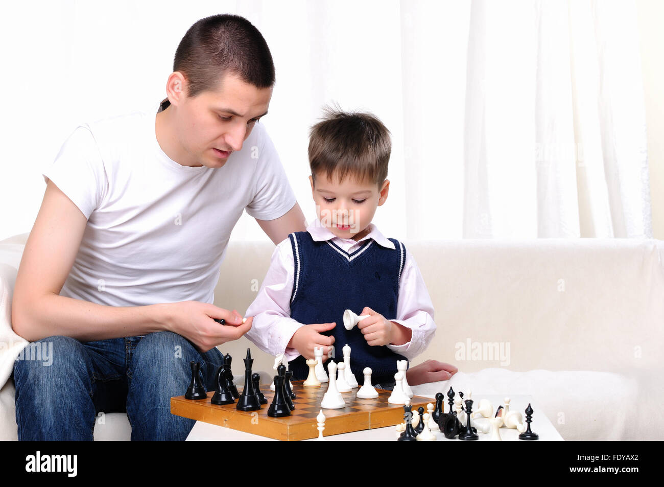 Dad and son playing chess at the table Stock Photo - Alamy
