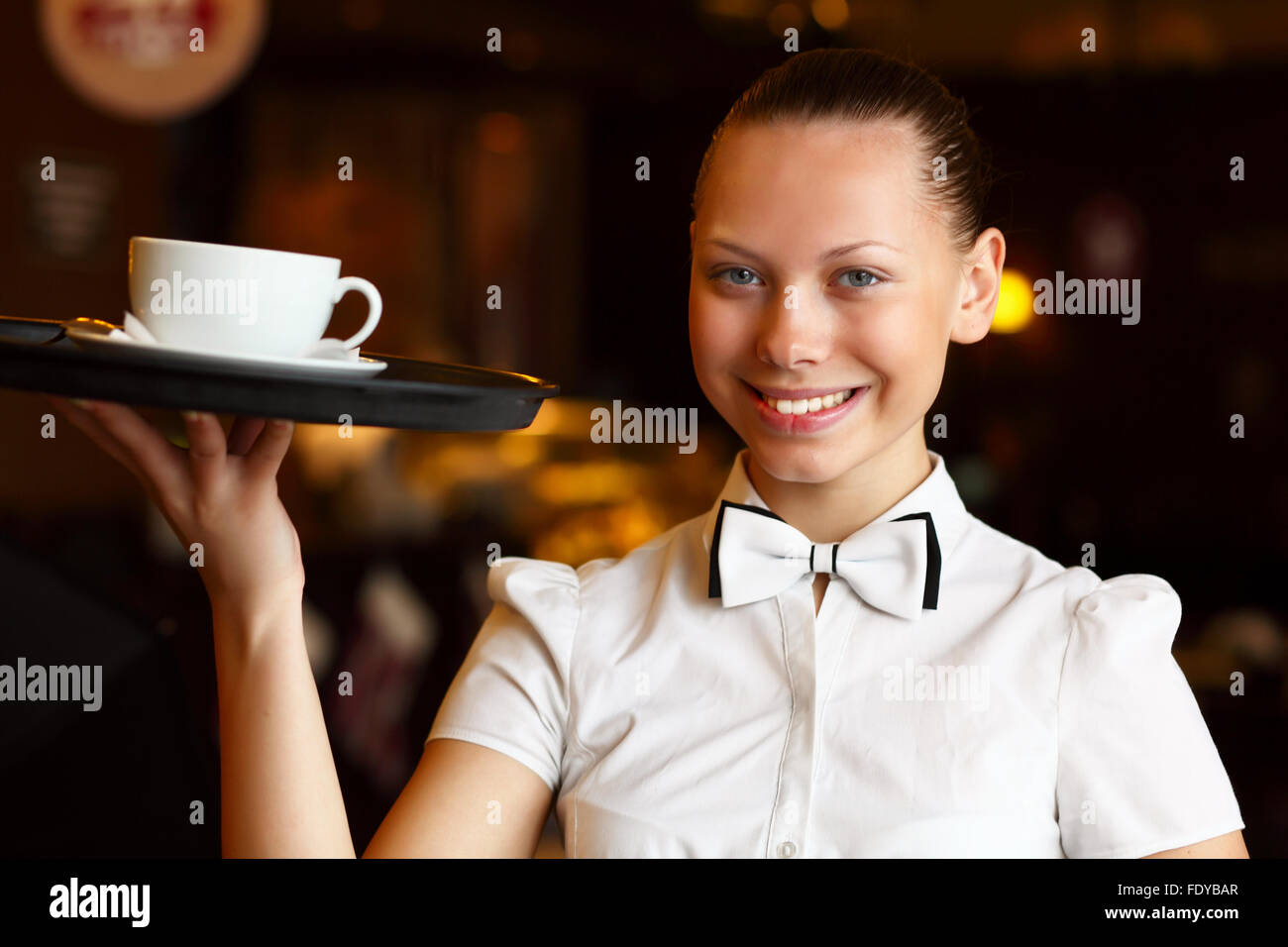 Portrait of young waitress in white blouse holding a tray Stock Photo ...
