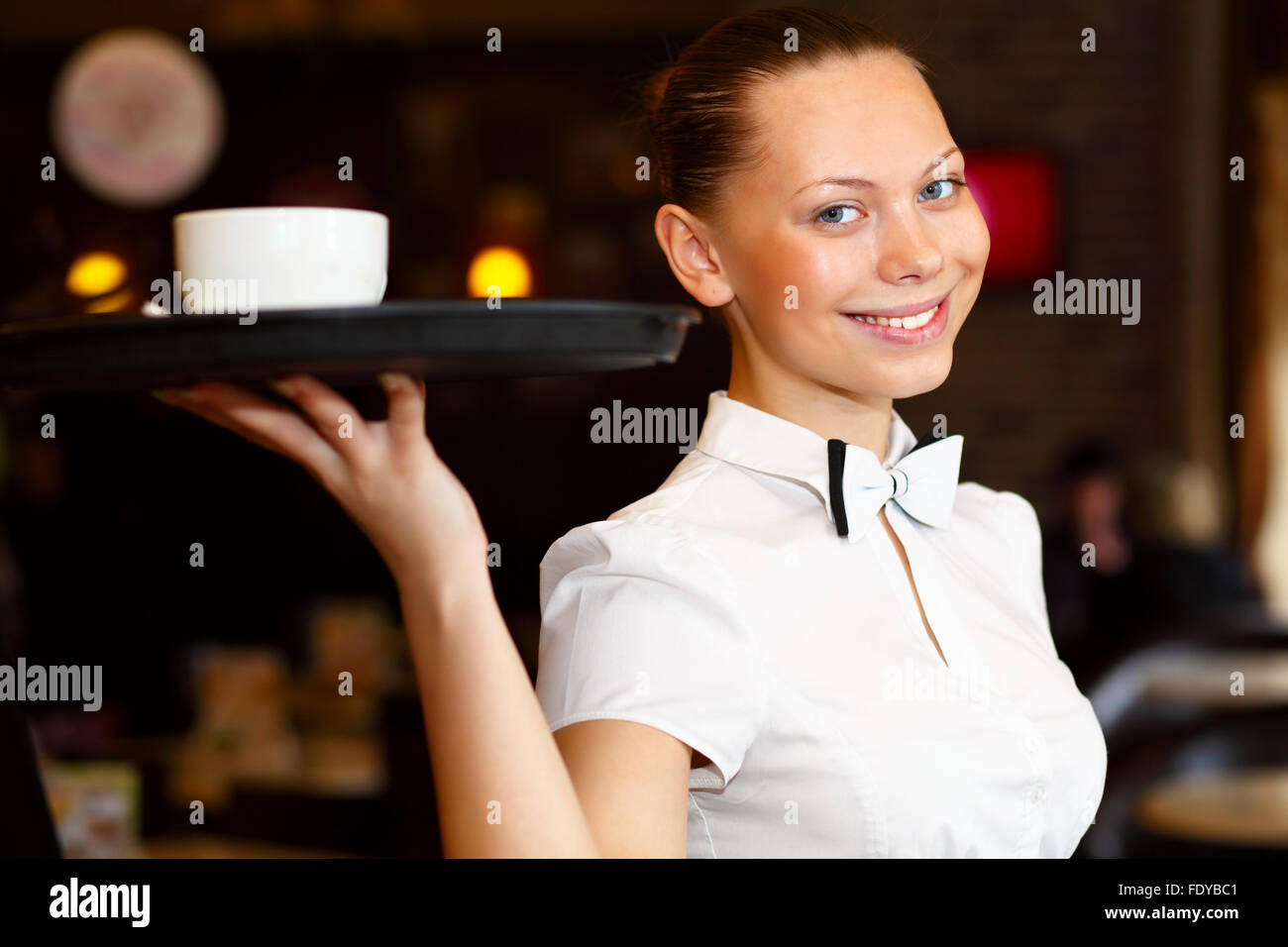 Portrait of young waitress in white blouse holding a tray Stock Photo ...