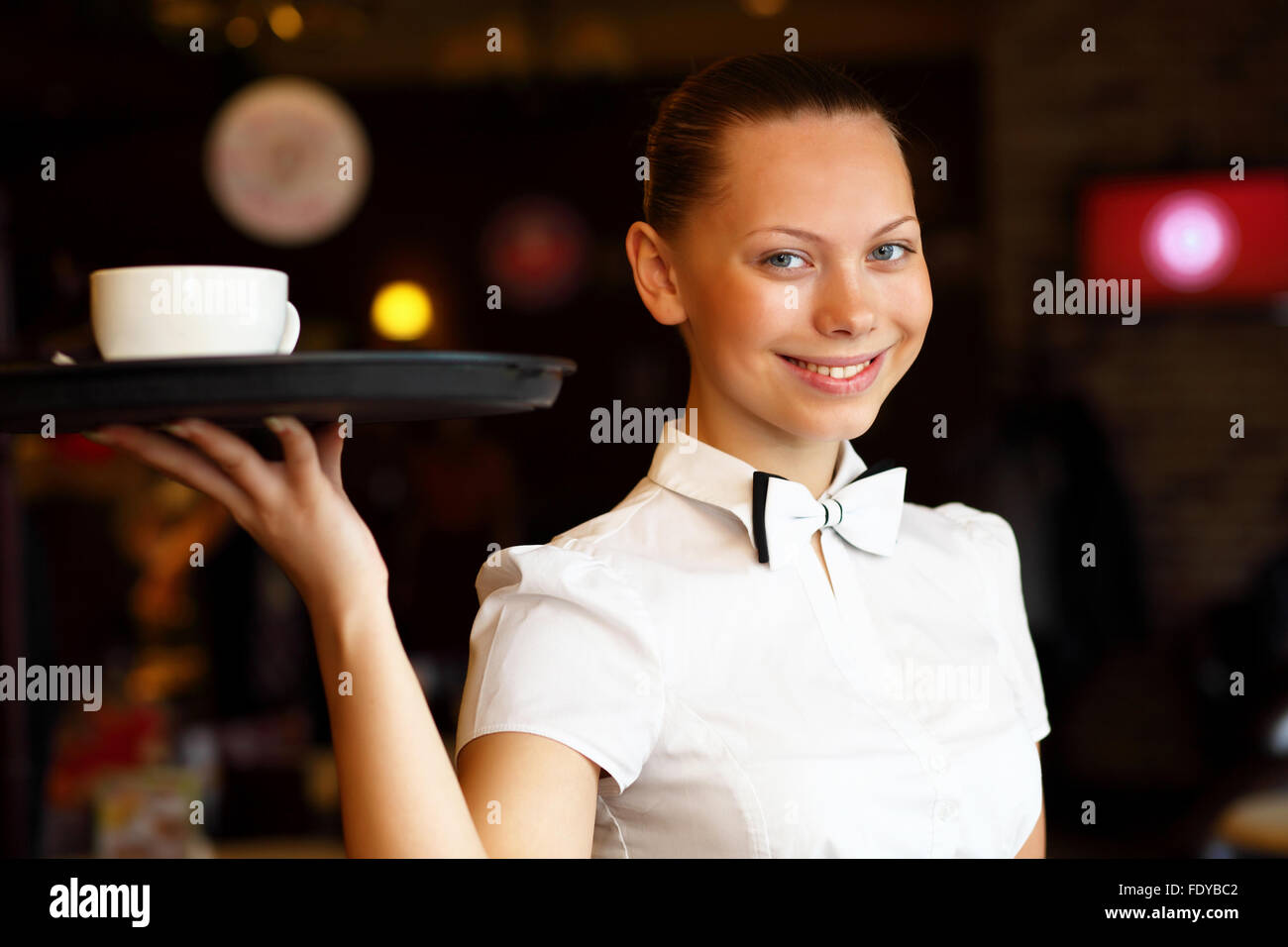 Portrait of young waitress in white blouse holding a tray Stock Photo ...