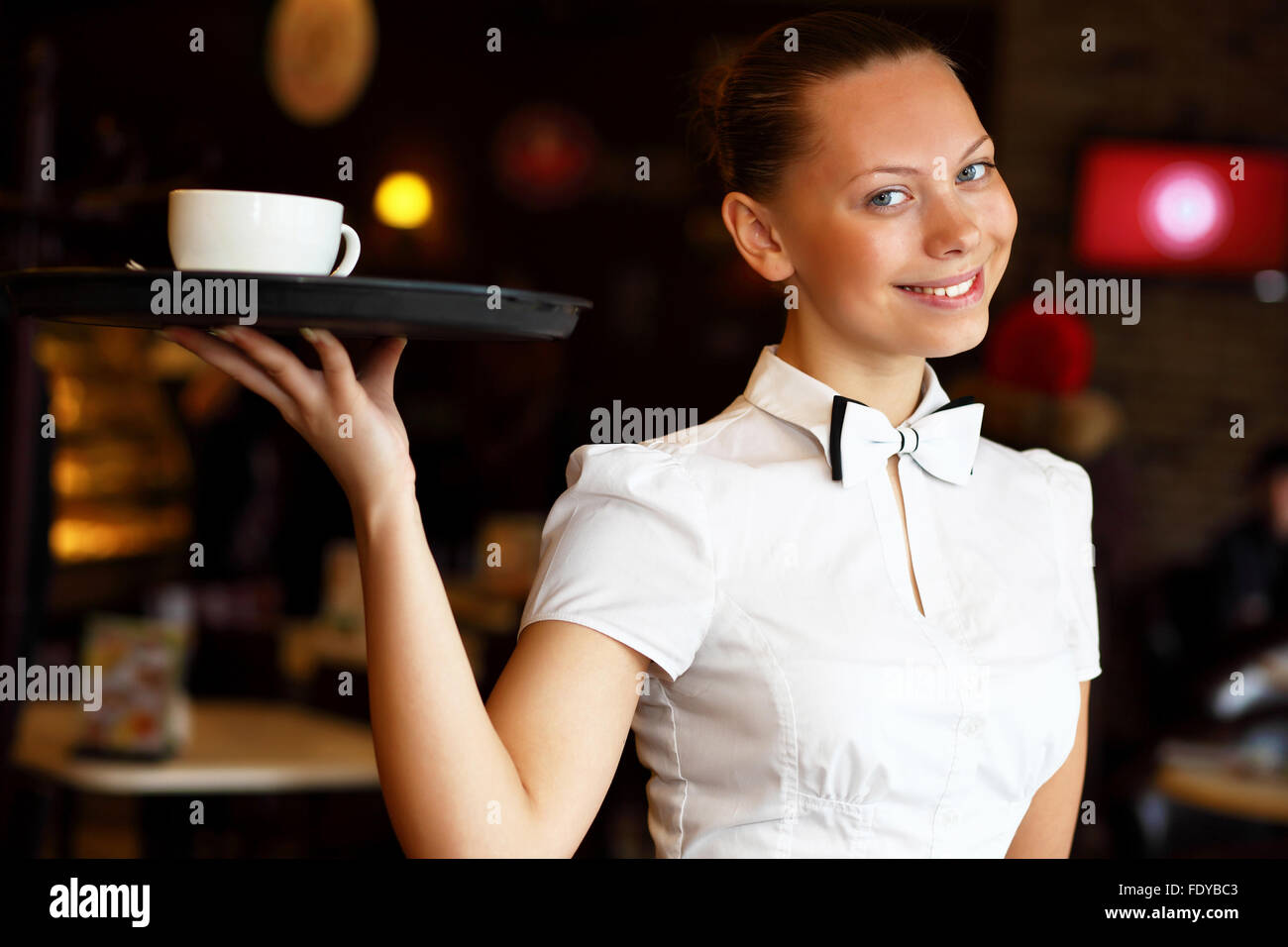 Portrait of young waitress in white blouse holding a tray Stock Photo ...