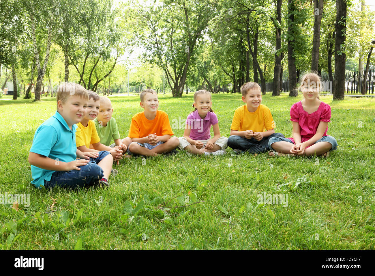 Group of children sitting together on teh grass in the park Stock Photo ...