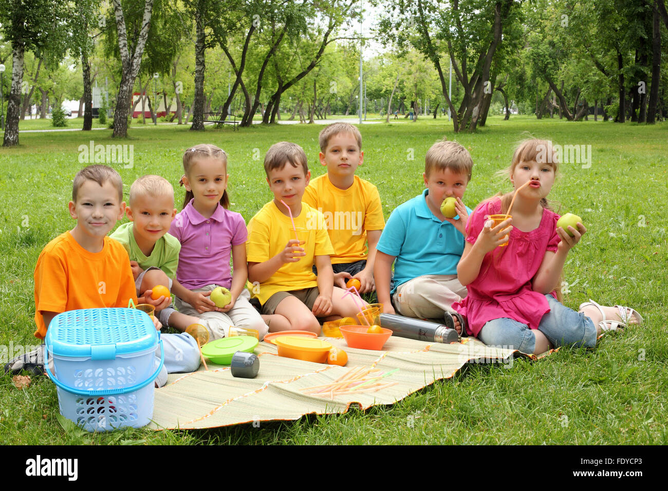 Group of children sitting together on teh grass in the park Stock Photo ...