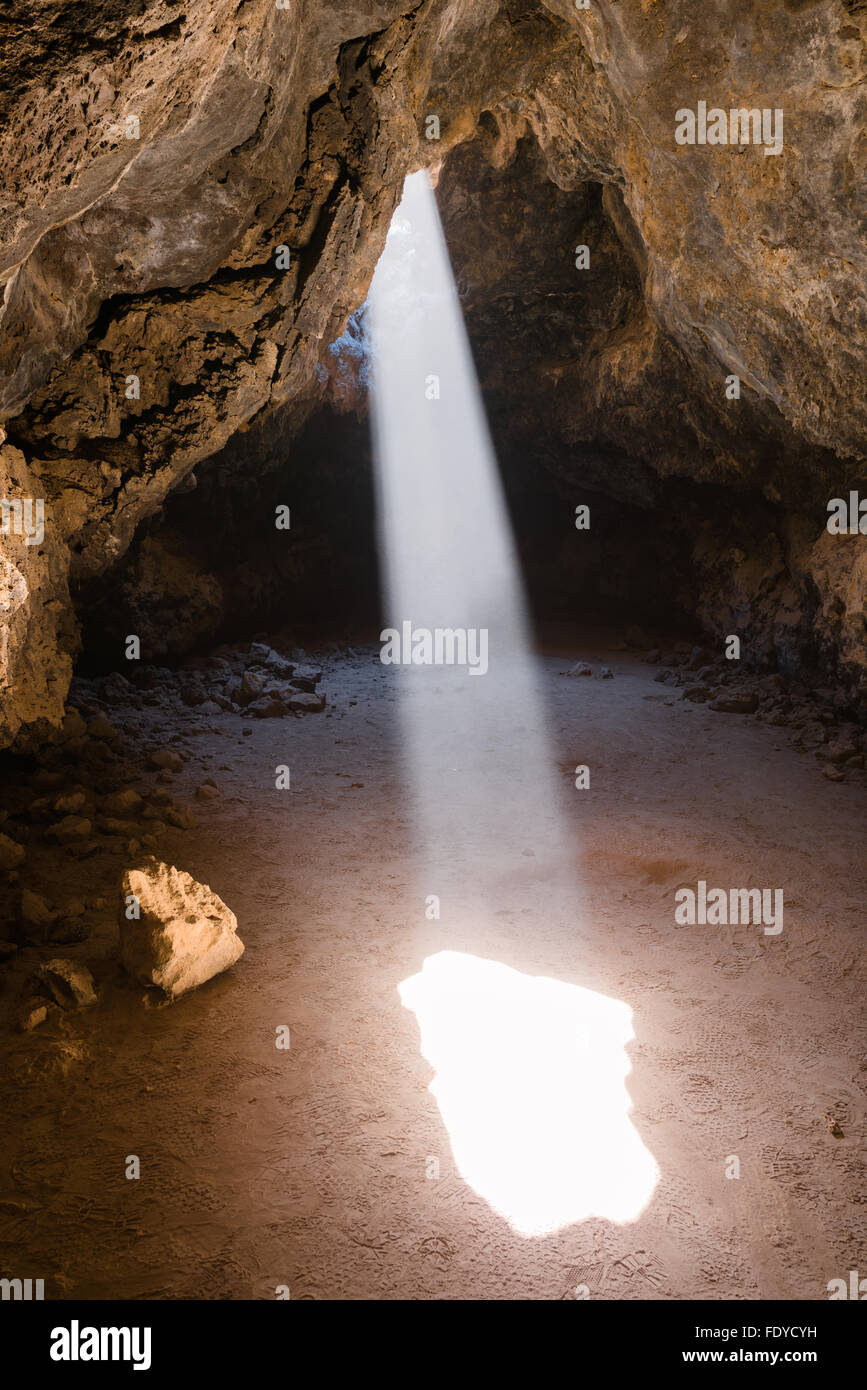 A beam of sunlight shining into a lava tube in Mojave National Preserve ...