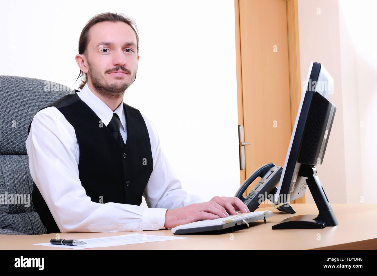 A young business man working on the computer in the office Stock Photo ...