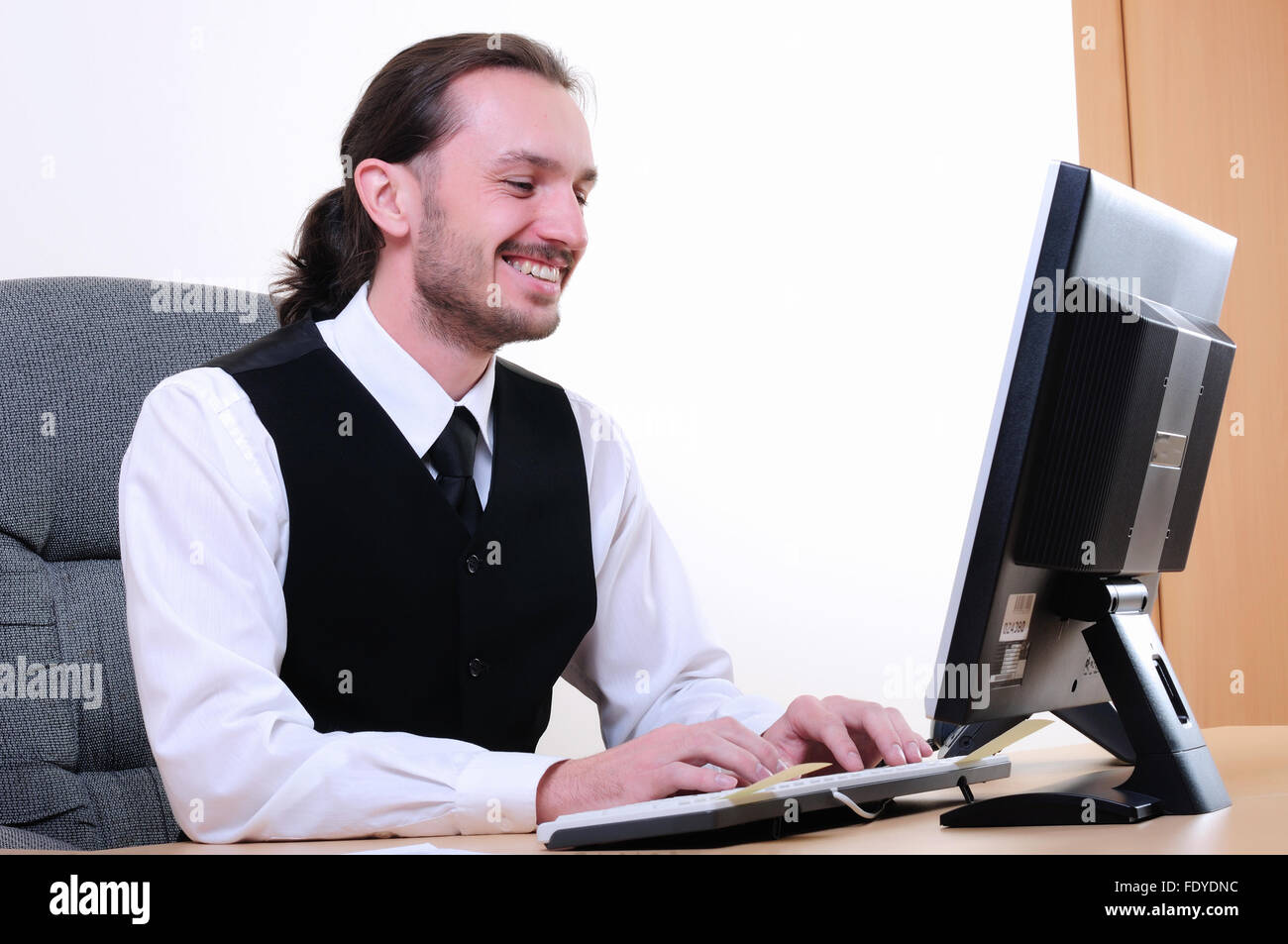 A young business man working on the computer in the office Stock Photo ...