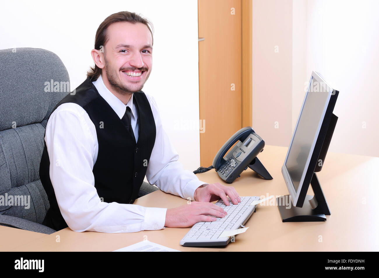 A young business man working on the computer in the office Stock Photo ...