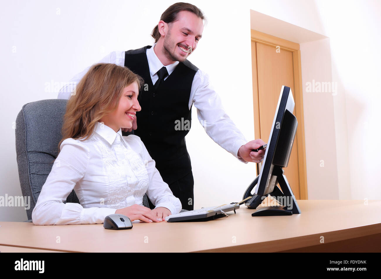 A young business man and a girl running on the computer in the office ...