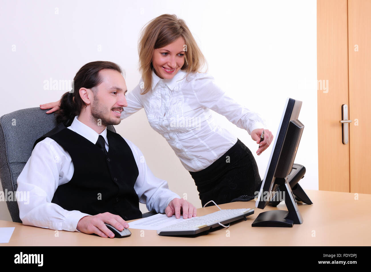 A young business man and a girl running on the computer in the office ...