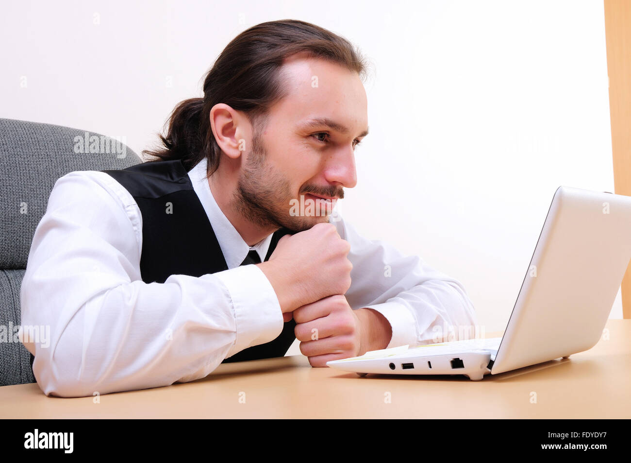 A young business man working on the computer in the office Stock Photo ...
