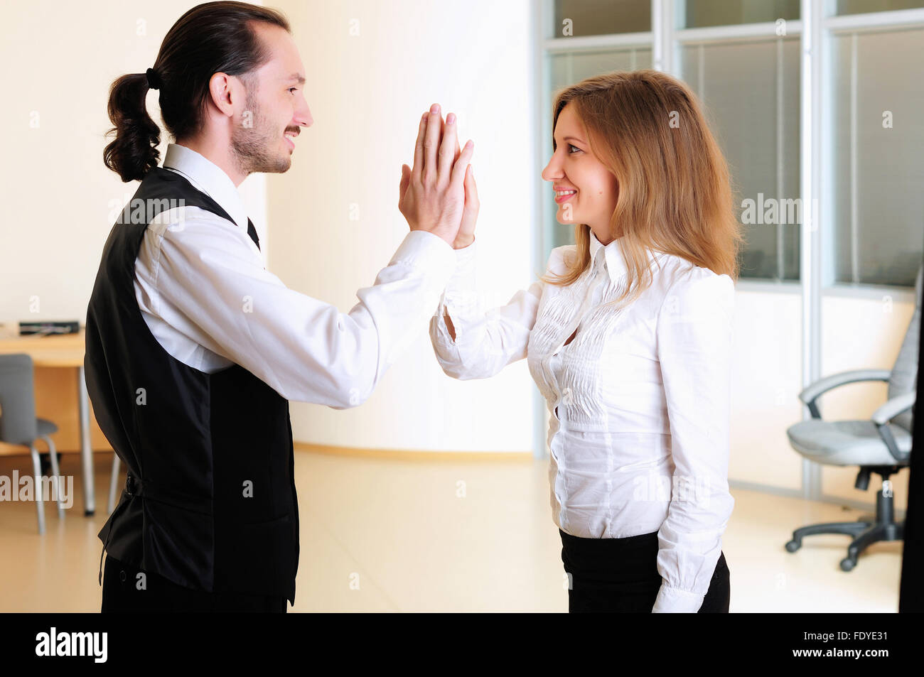 A young girl claps her hands to his colleague in the office Stock Photo ...