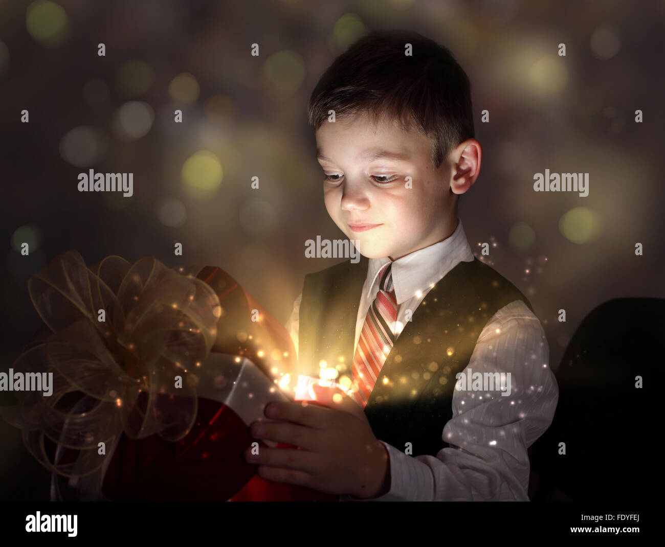 Child opening a magic gift box with lights and shining around Stock ...