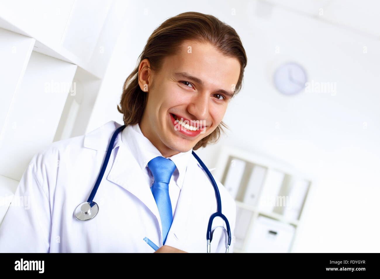 Young confident and friendly doctor in medical office Stock Photo - Alamy