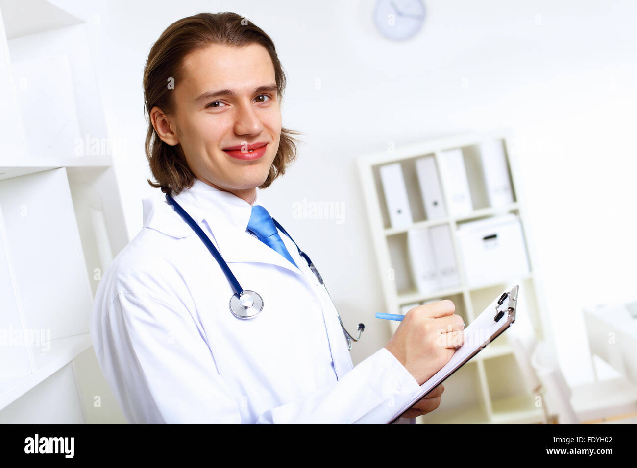 Young confident and friendly doctor in medical office Stock Photo - Alamy