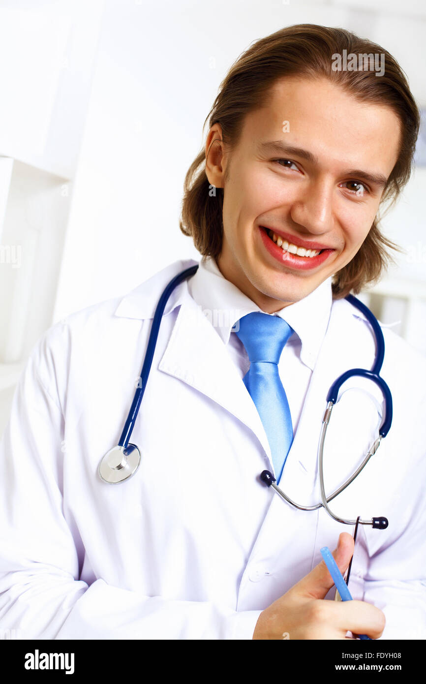 Young confident and friendly doctor in medical office Stock Photo - Alamy