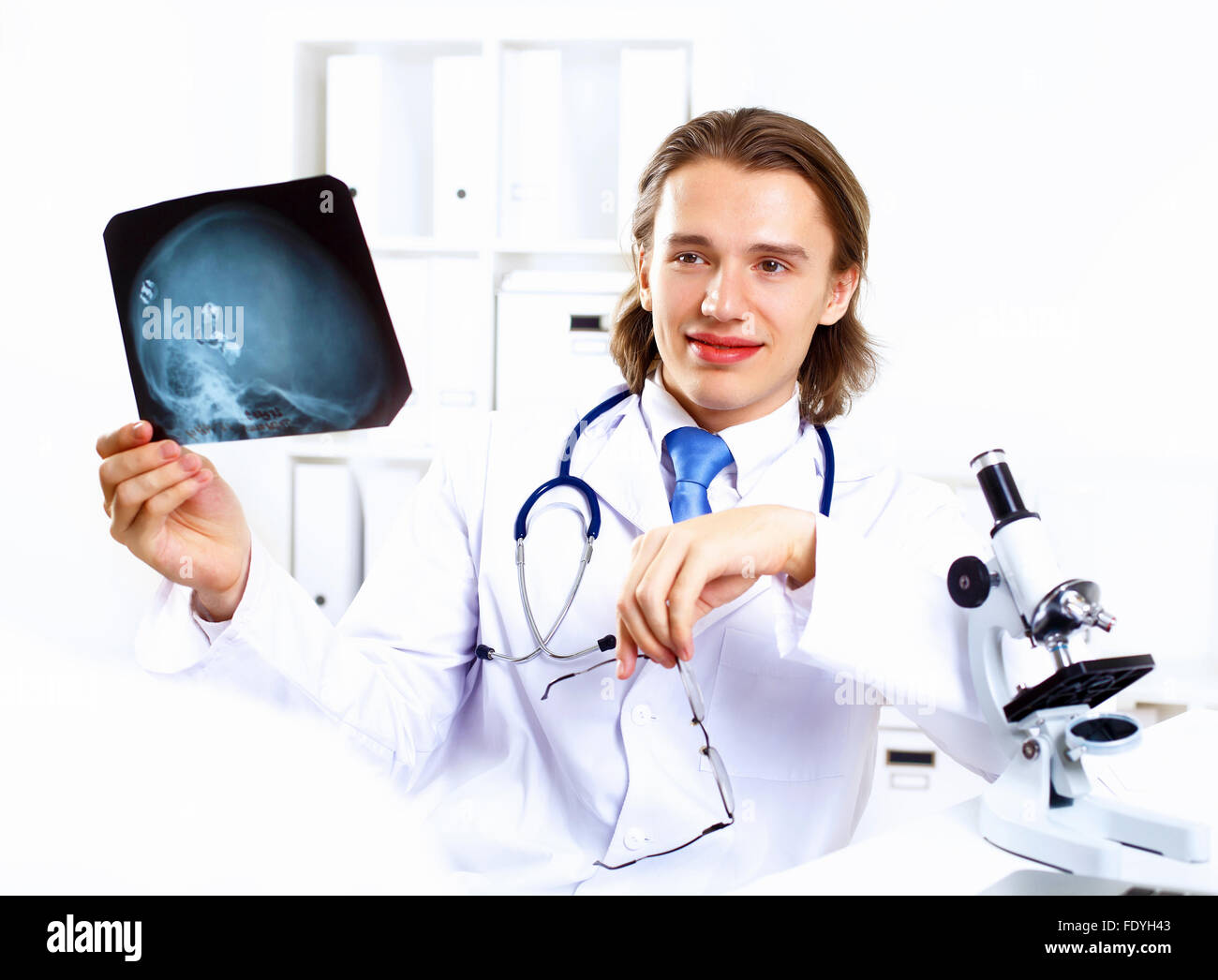 Young confident and friendly doctor in medical office Stock Photo - Alamy
