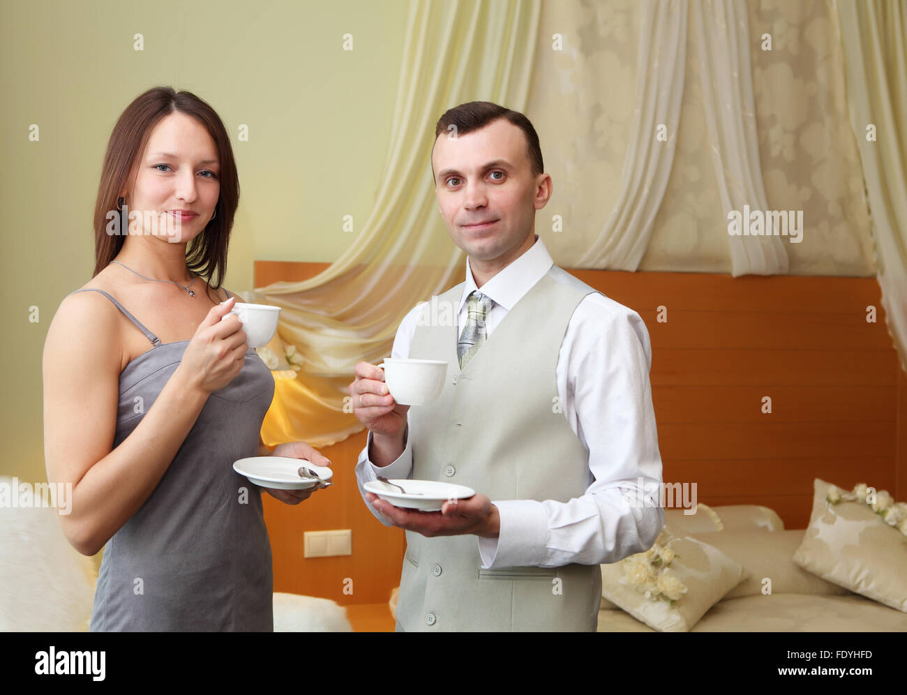 young couple standing together and holding tea cups Stock Photo - Alamy
