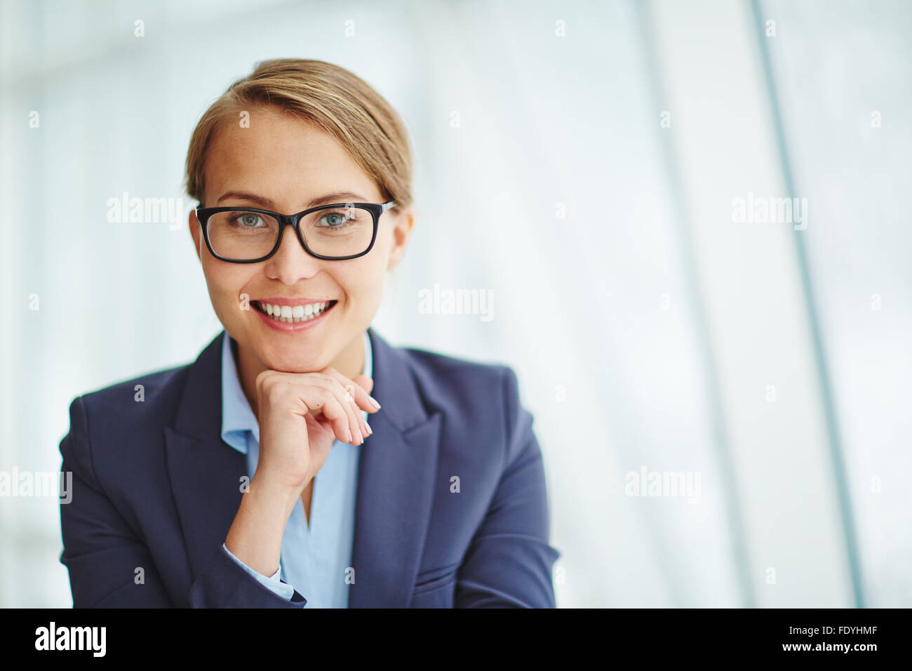 Young Businesswoman In Eyeglasses Looking At Camera With Toothy Smile