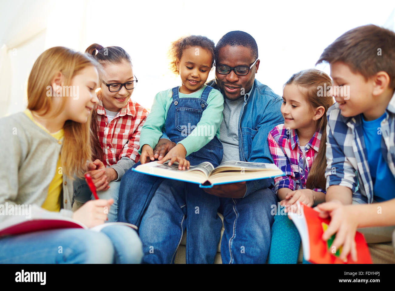 Group of pupils and their teacher reading together Stock Photo - Alamy