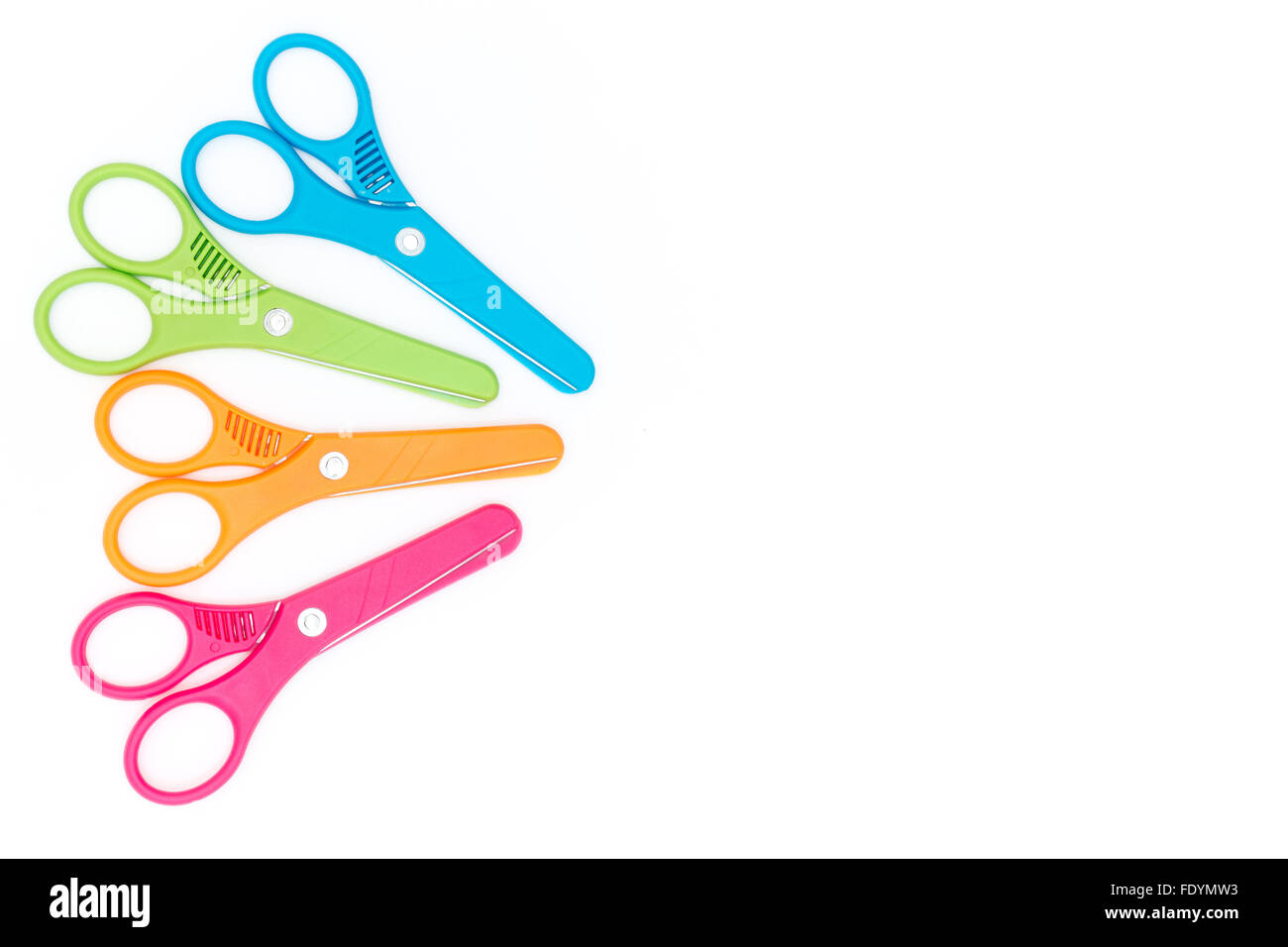 Red, orange, green, and blue plastic kids safety scissors arranged on a ...