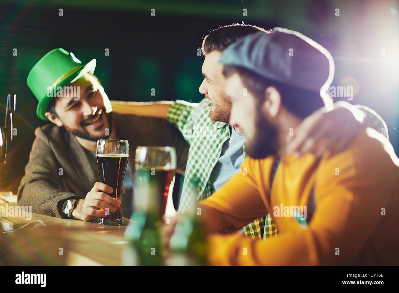 Friendly men drinking beer and talking in pub Stock Photo - Alamy