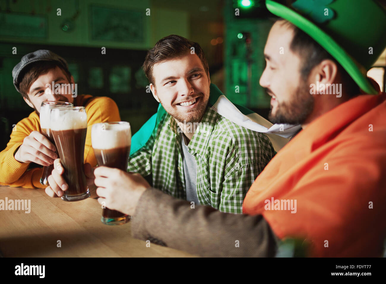 Cheerful guys with beer and Irish flag sitting in pub Stock Photo - Alamy