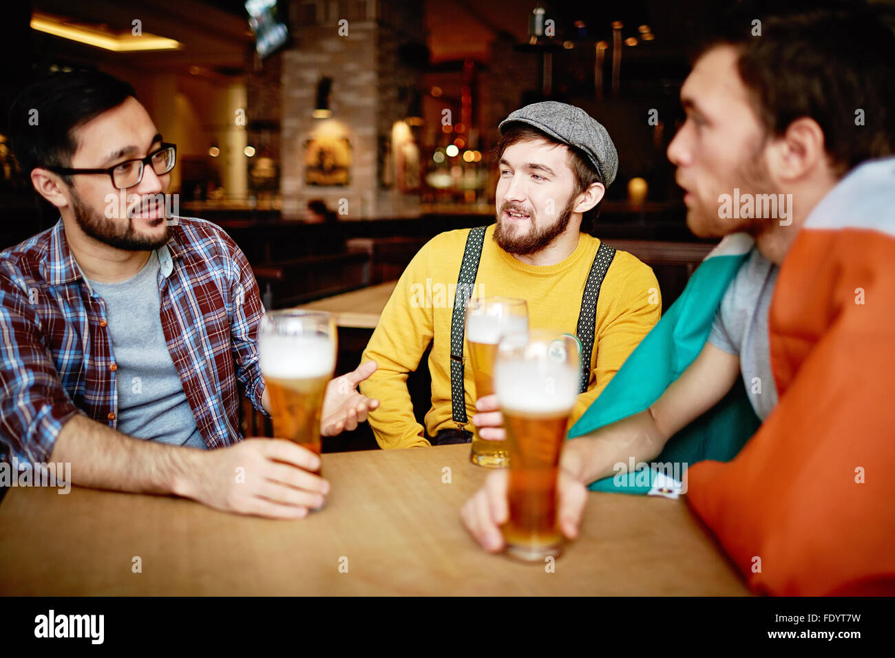 Group of multi-ethnic men talking in pub while drinking beer Stock ...