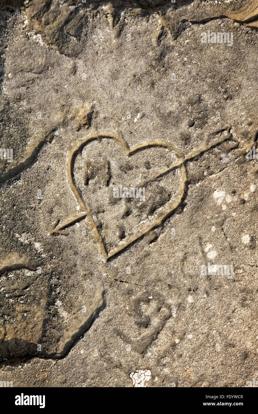 Heart and arrow engraved on rocky beach Stock Photo - Alamy