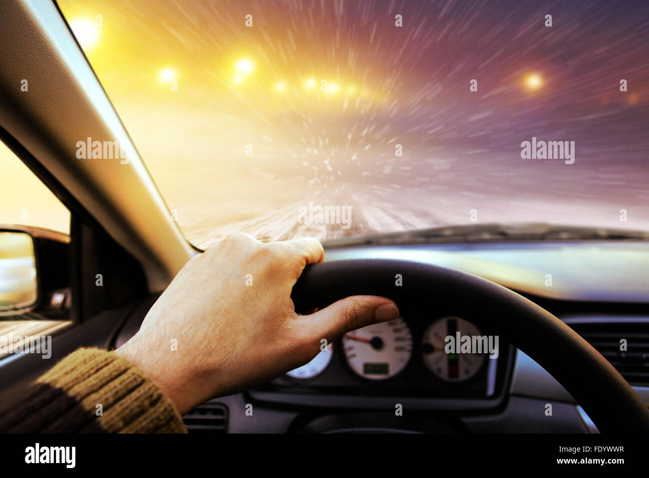 Driving on snow covered winter road with shining streetlights at night ...