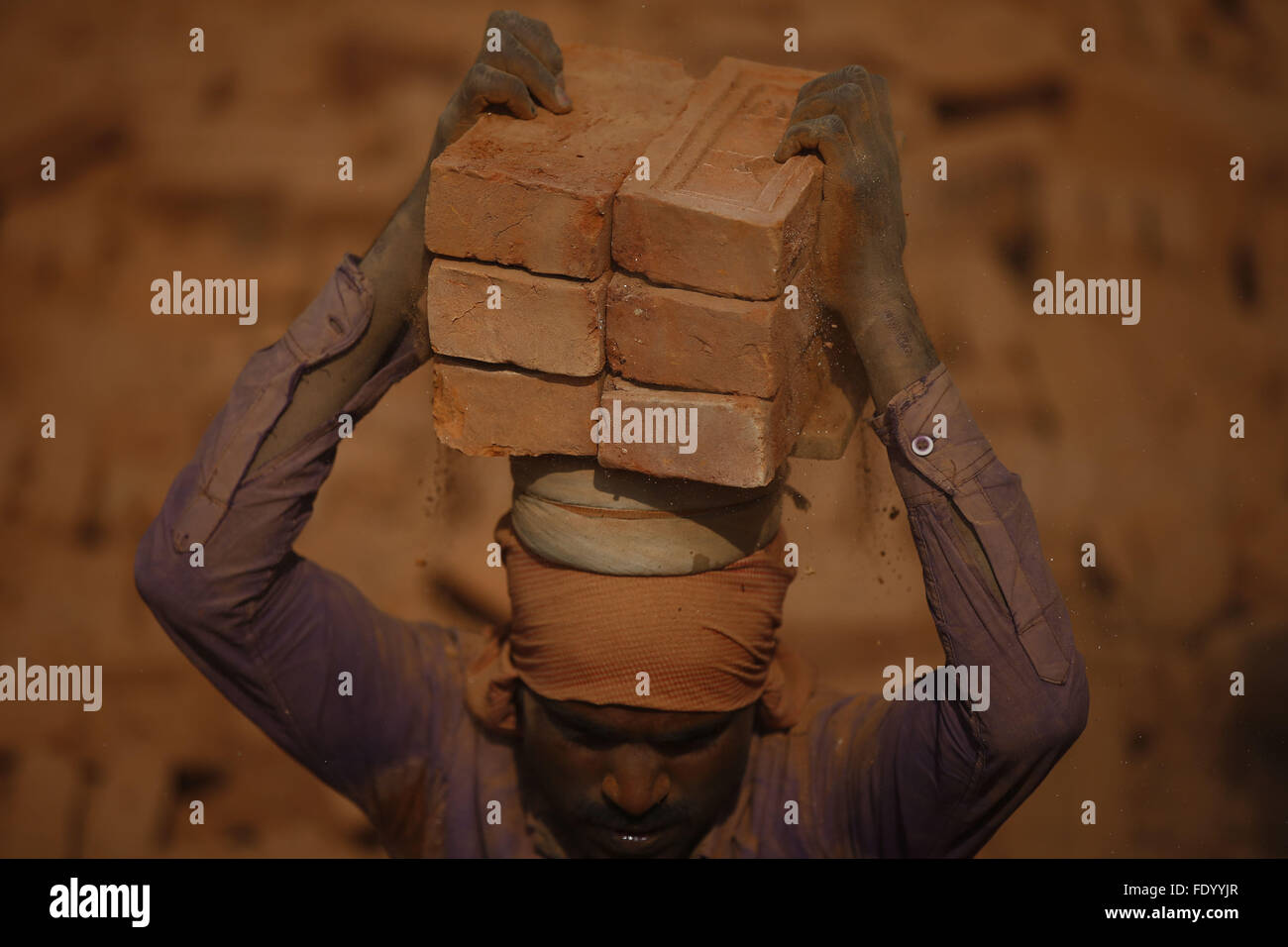 Feb. 3, 2016 - Bhaktapur, Nepal - A migrant worker stacks bricks onto ...