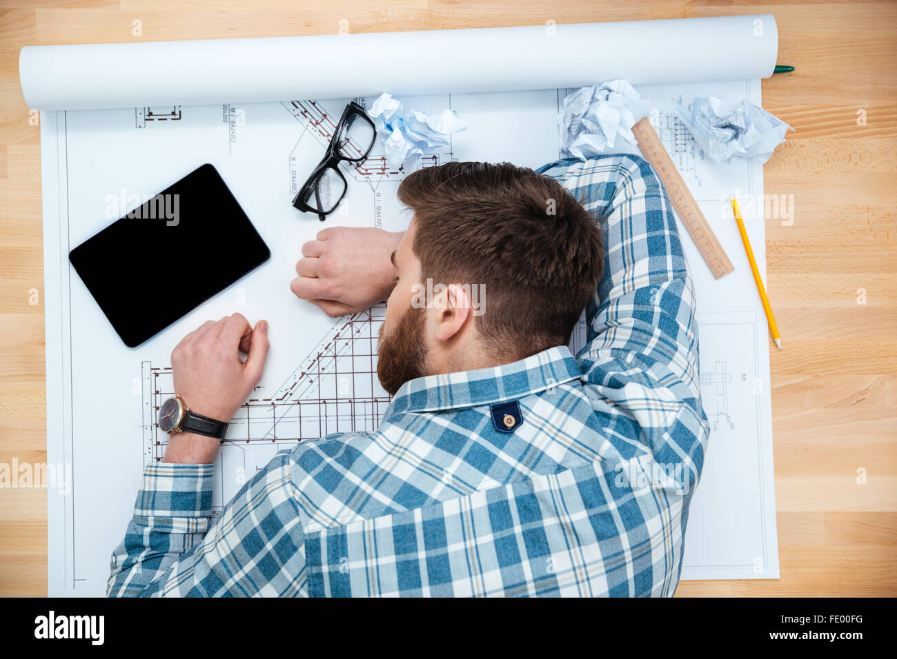 Top view of exhausted bearded young architect sleeping on workplace ...