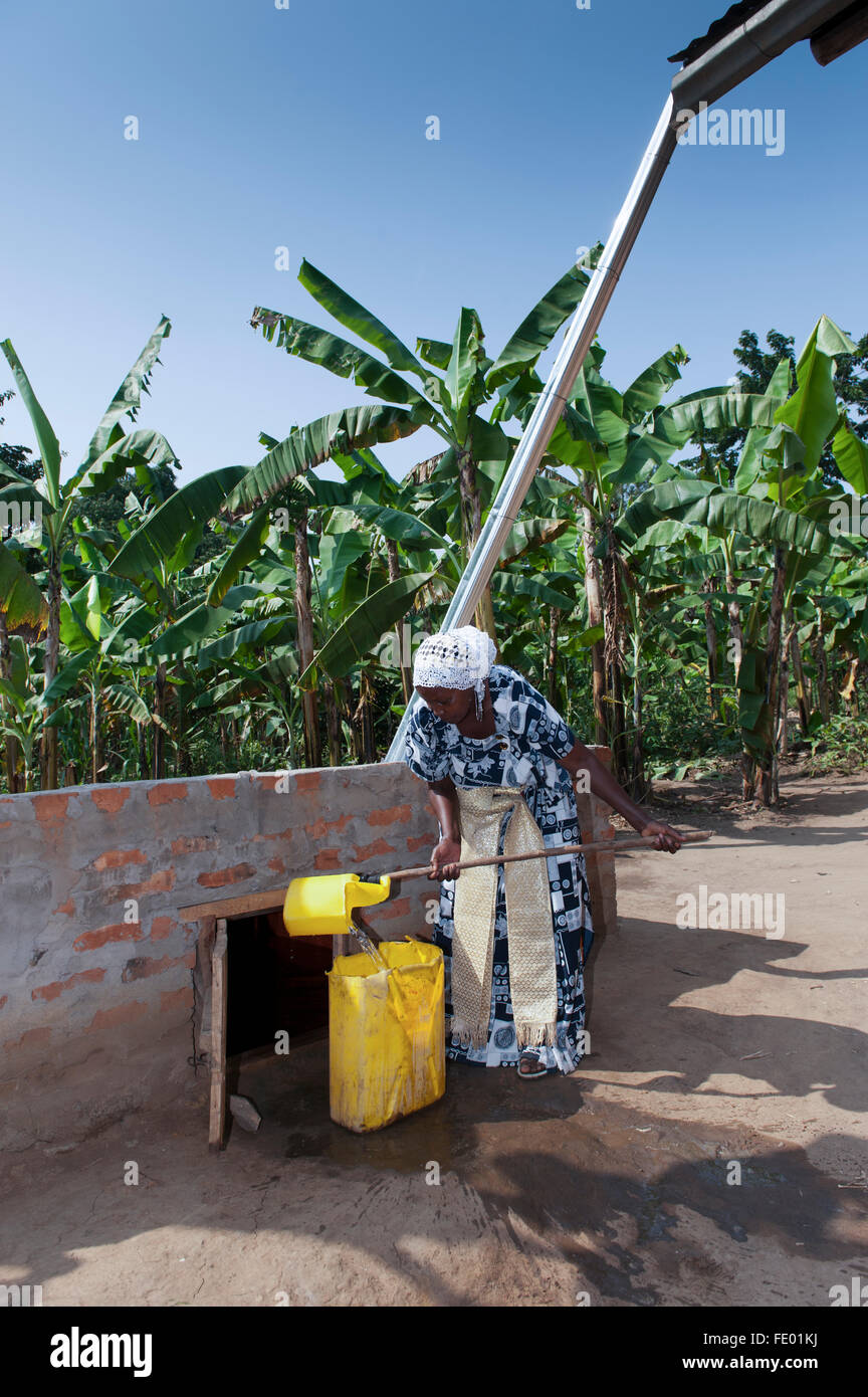 Lady getting water from an uderground store, supplied by water from ...