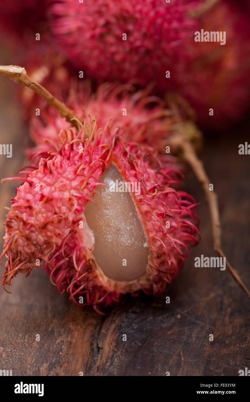 fresh tropical rambutan fruits over rustic wood table Stock Photo - Alamy