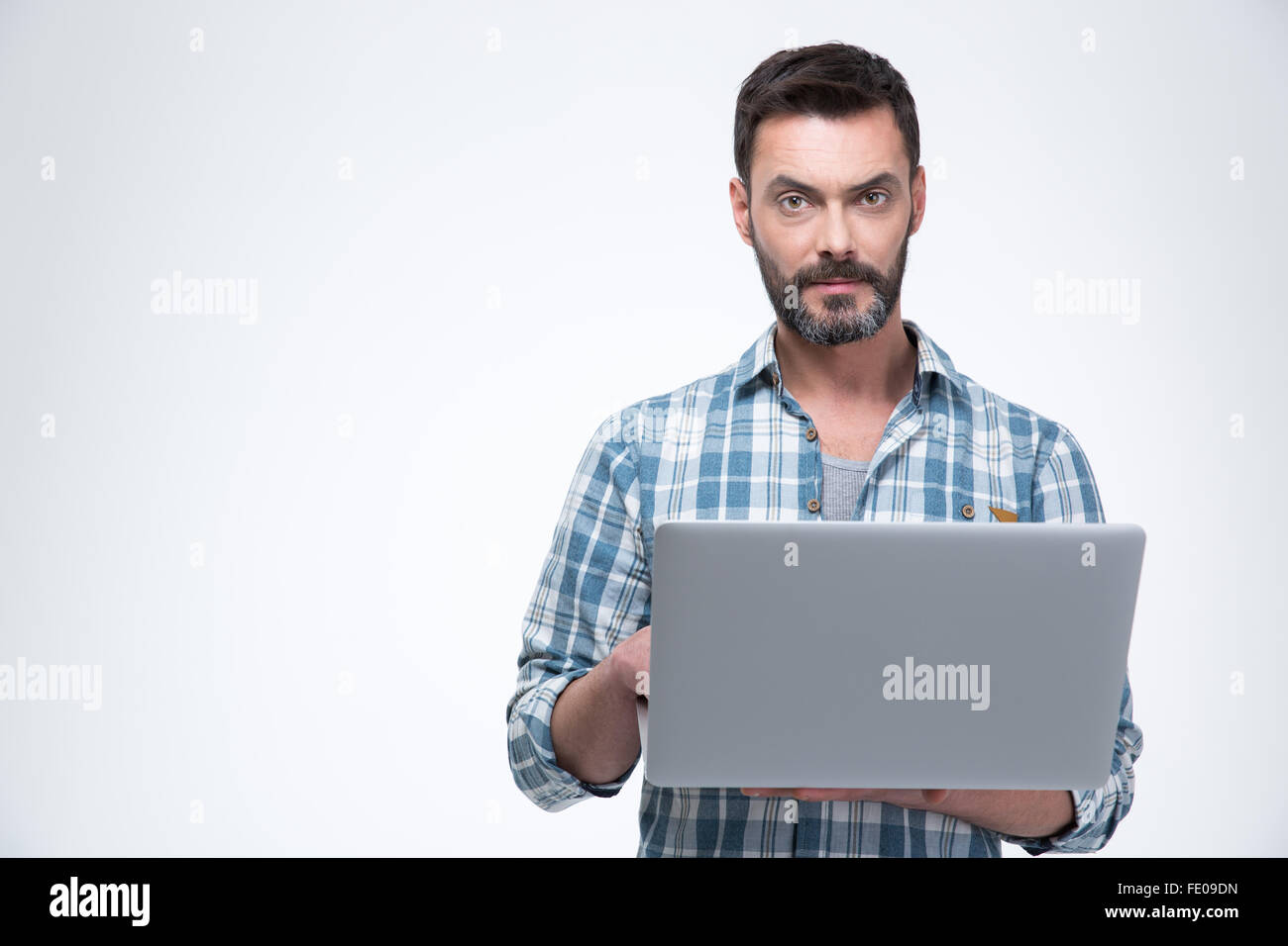 Serious man using laptop computer isolated on a white background and ...