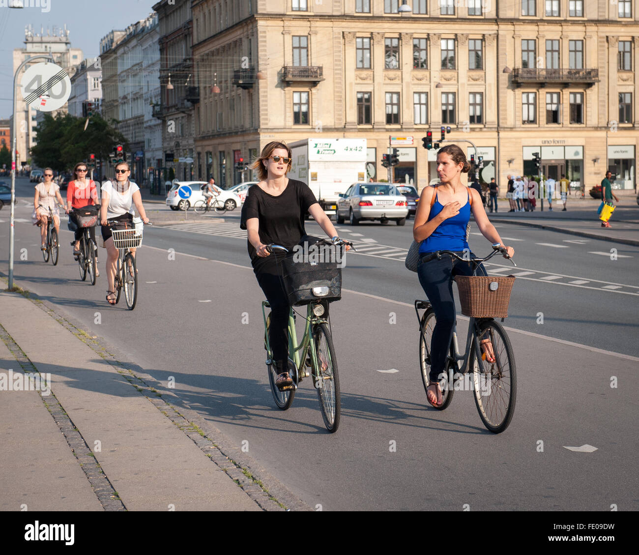 Young Danish women riding bikes around town on Dronning Louises Bro in ...