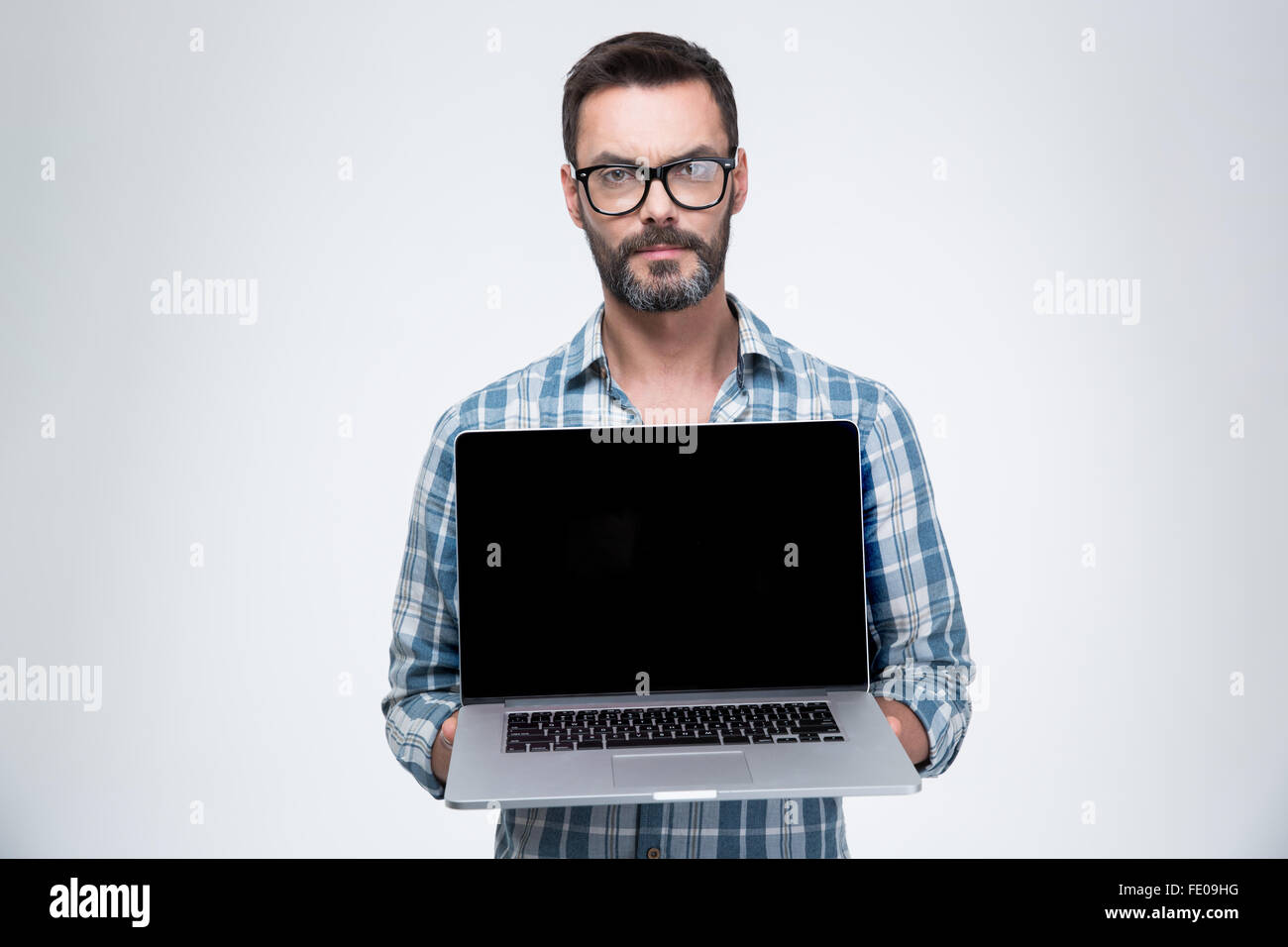 Handsome man showing blank laptop computer screen isolated on a white ...