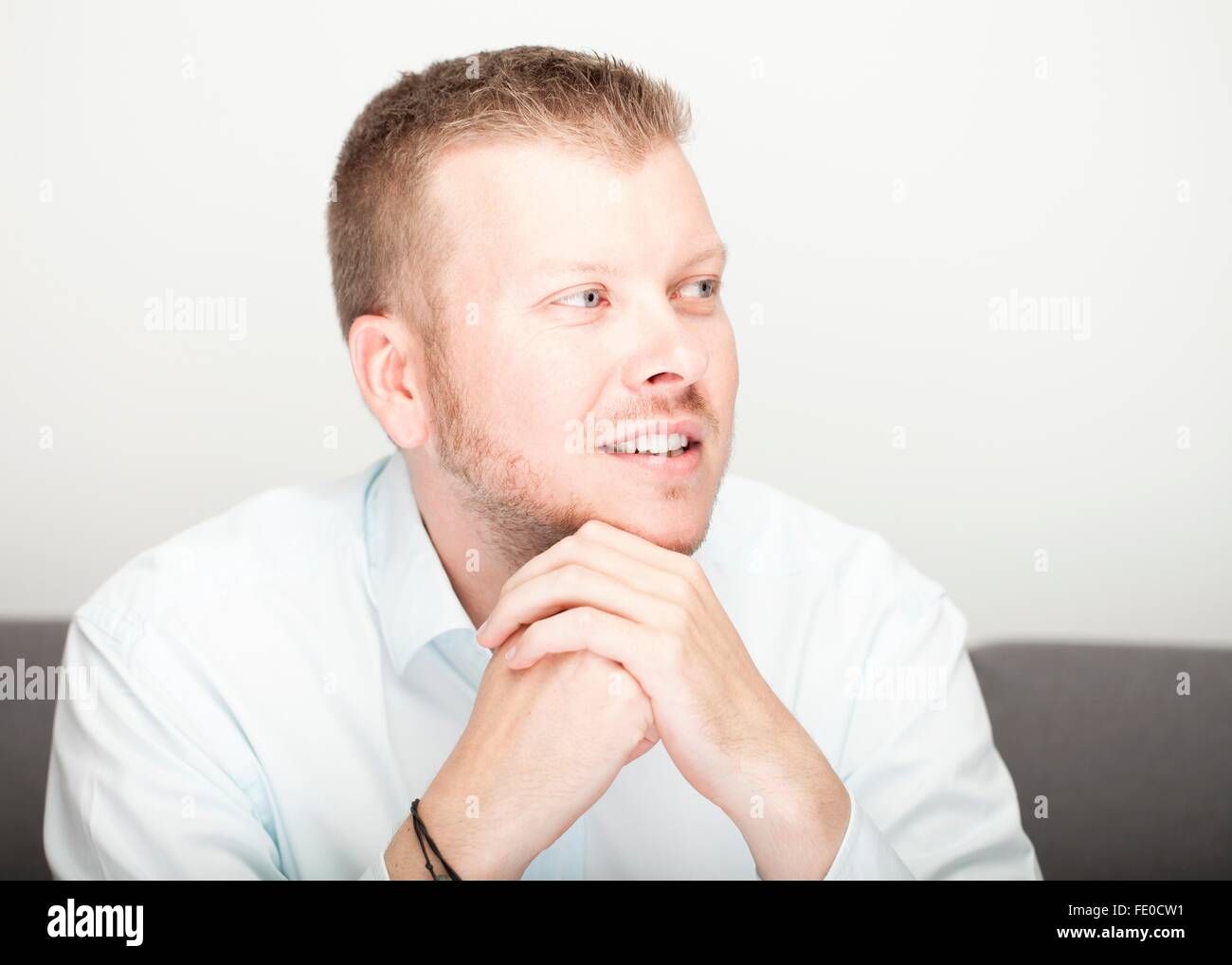 Young man resting his chin on his hands watching something off to the ...