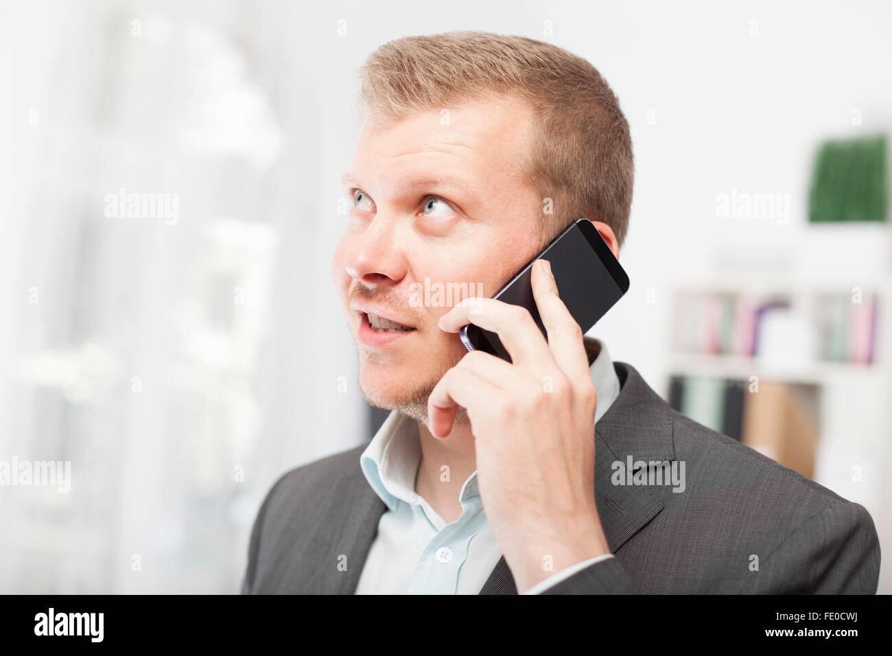 Businessman listening with anticipation to a call on his mobile phone ...