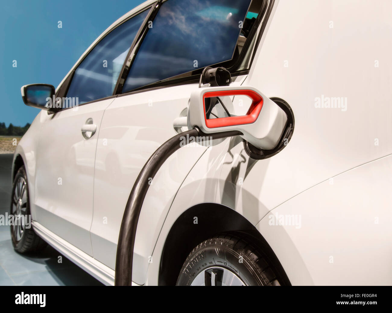 An electric car is connected to a charging station and is being charged ...