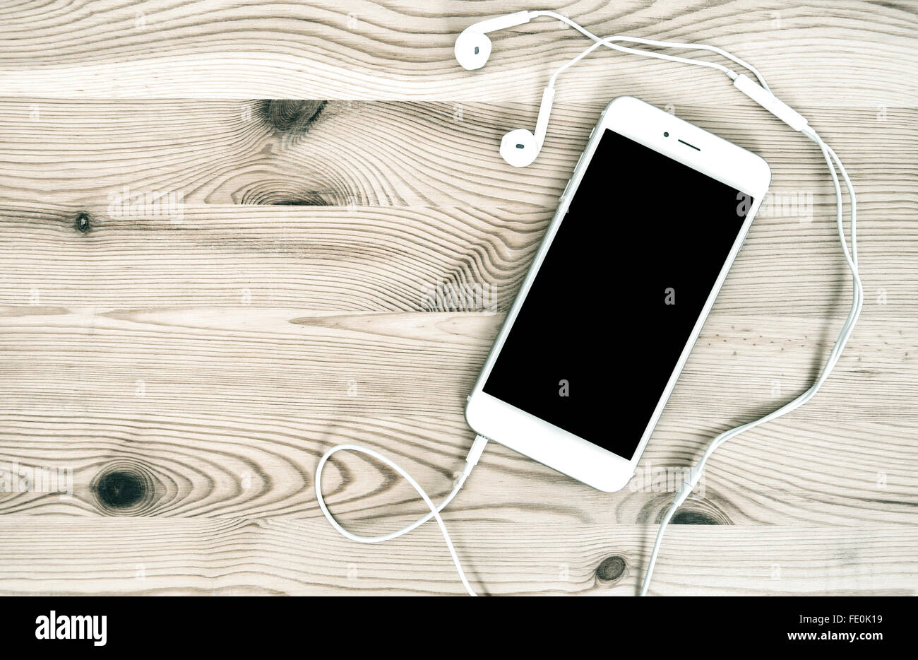 Digital mobile phone with headphones on wooden background Stock Photo ...