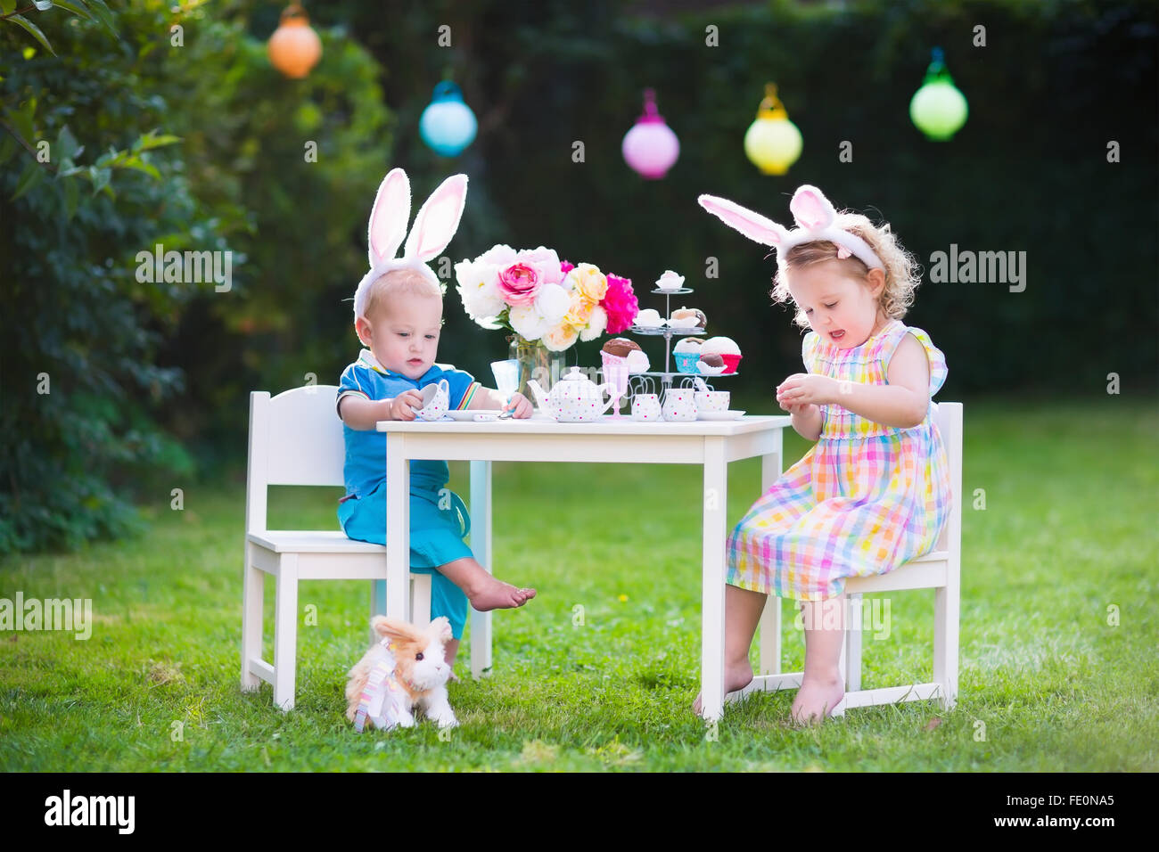 Little boy and girl play toy tea party outdoors. Children with bunny ...