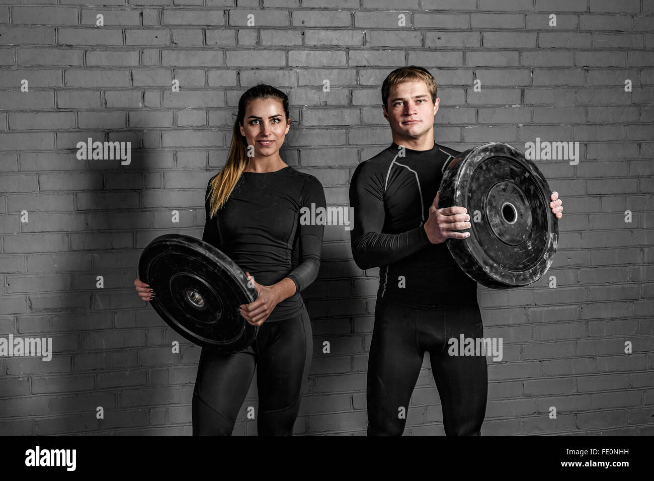 Couple of sporty man and woman with weigh Stock Photo - Alamy