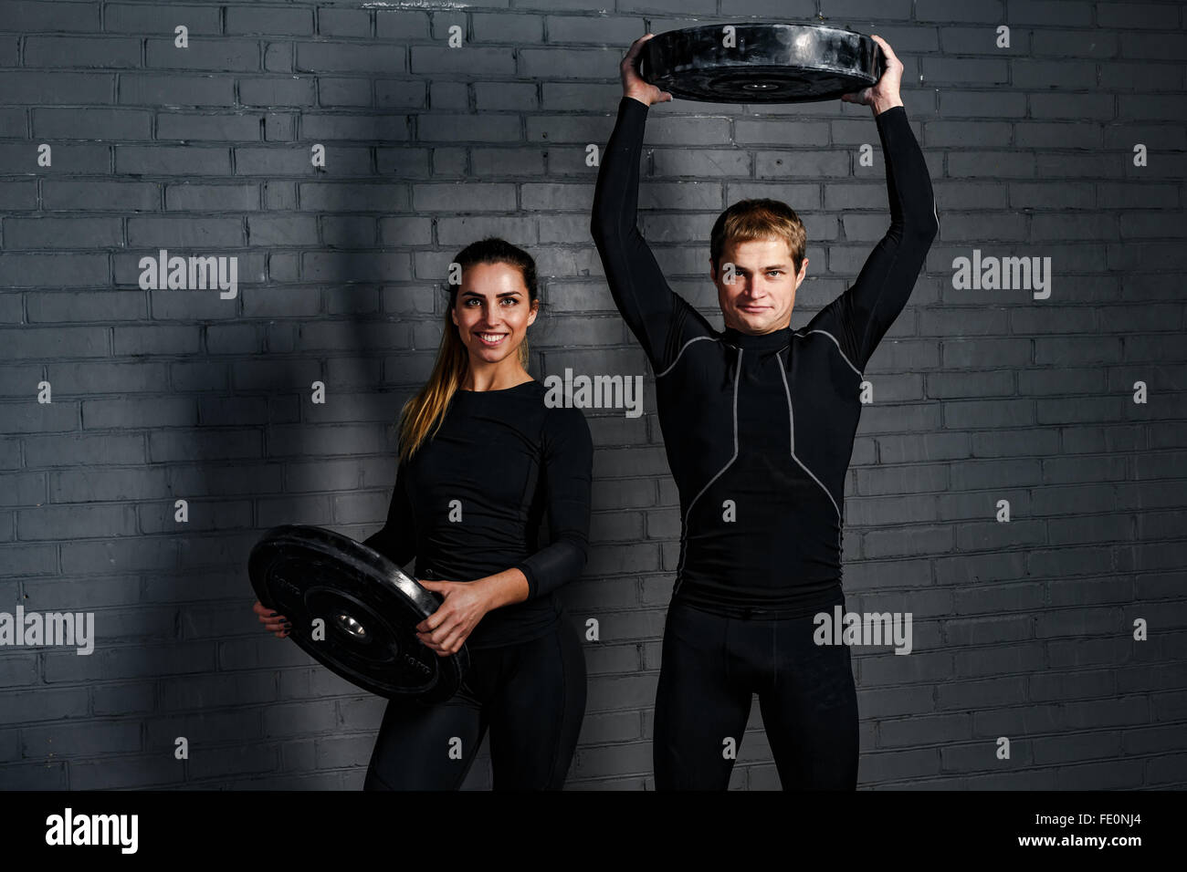Strong man an sporty woman in gym Stock Photo - Alamy