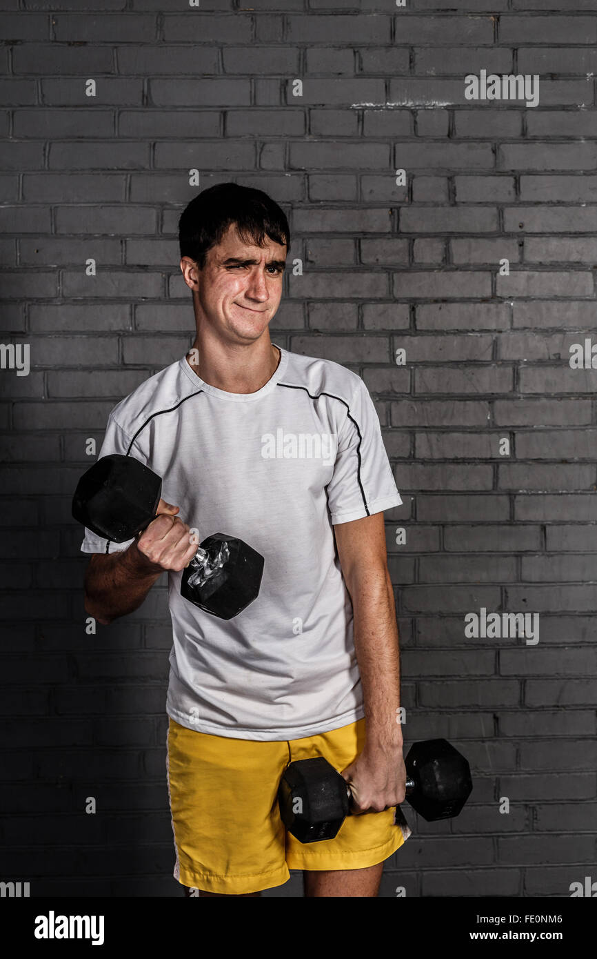 nerd trains in the gym with dumbbells Stock Photo - Alamy