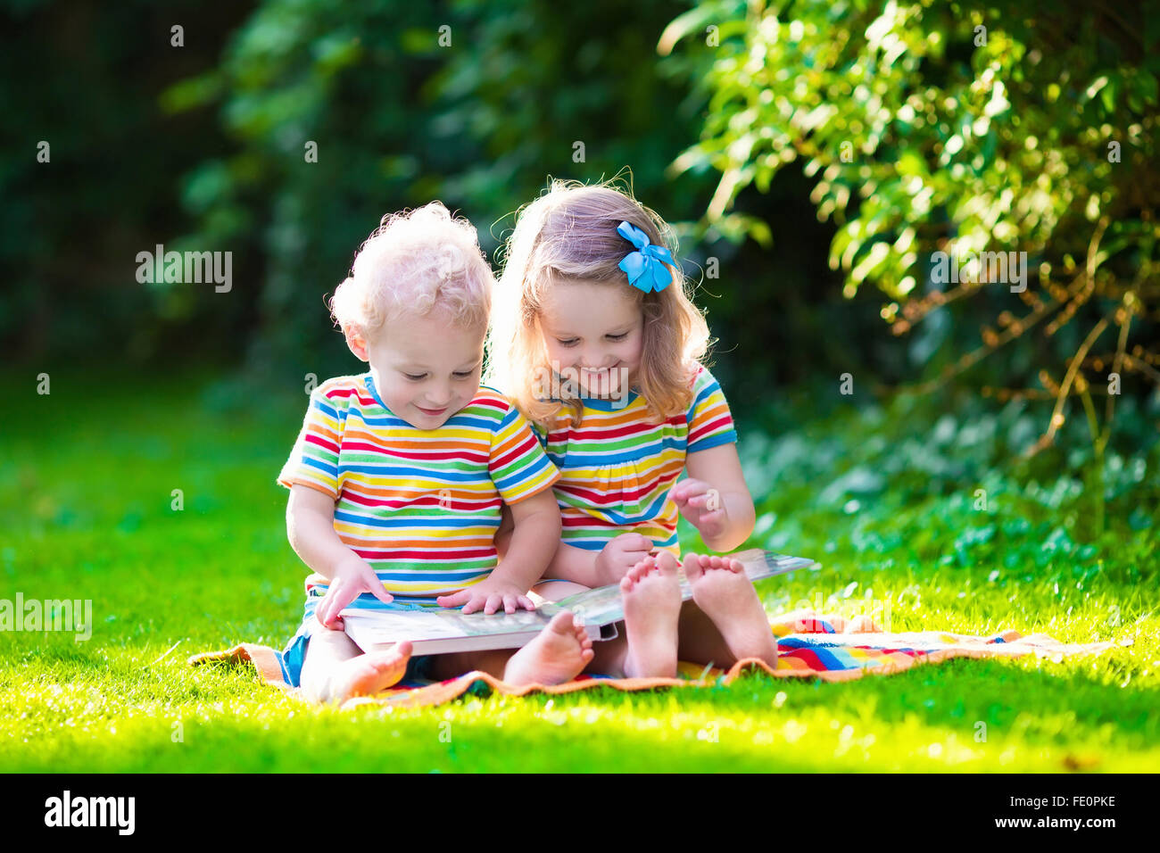 Kids reading a book in summer garden. Children study. Boy and girl play ...