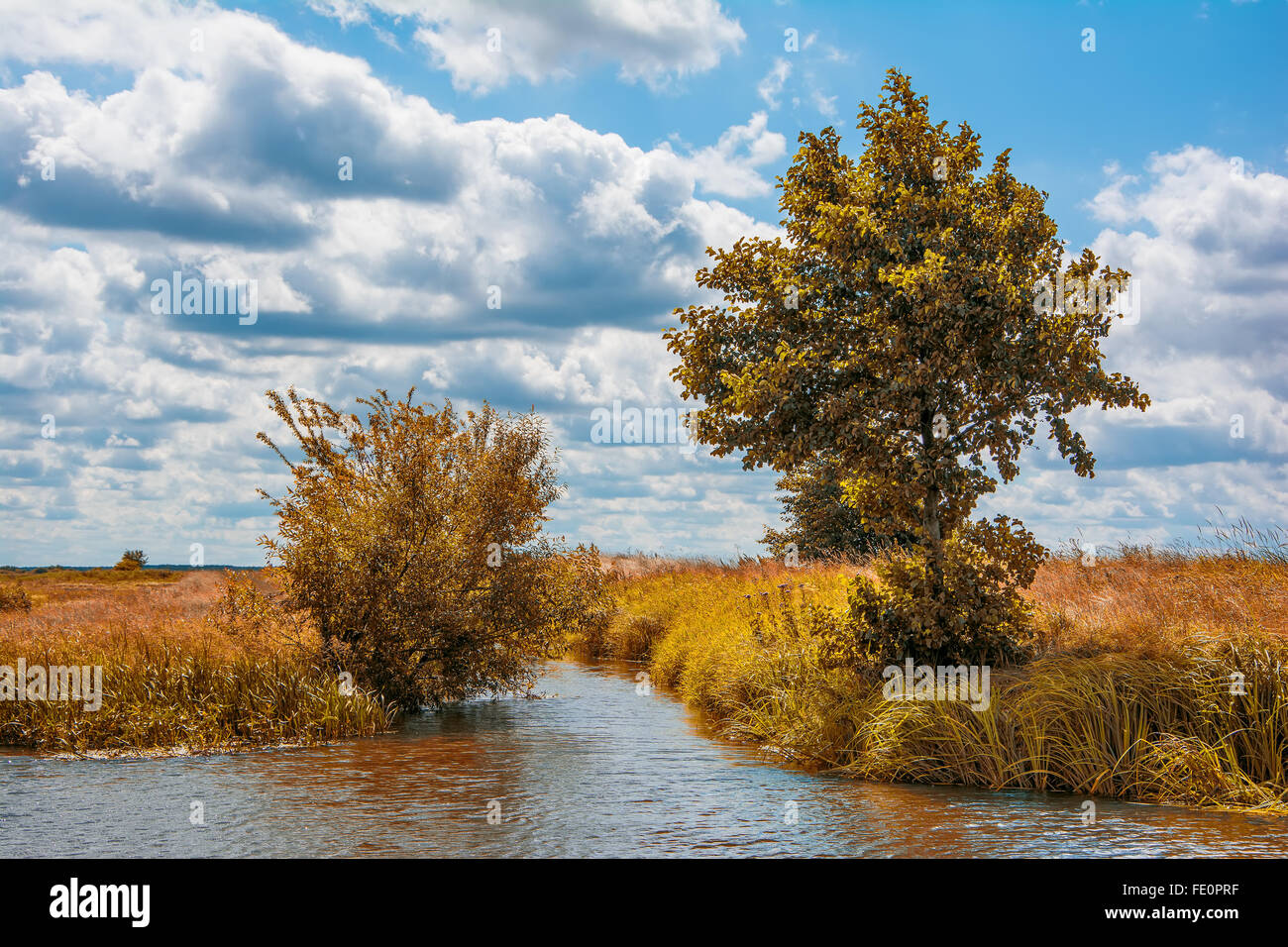 Fall landscape with river, trees and stormy clouds in the sky. Nature ...