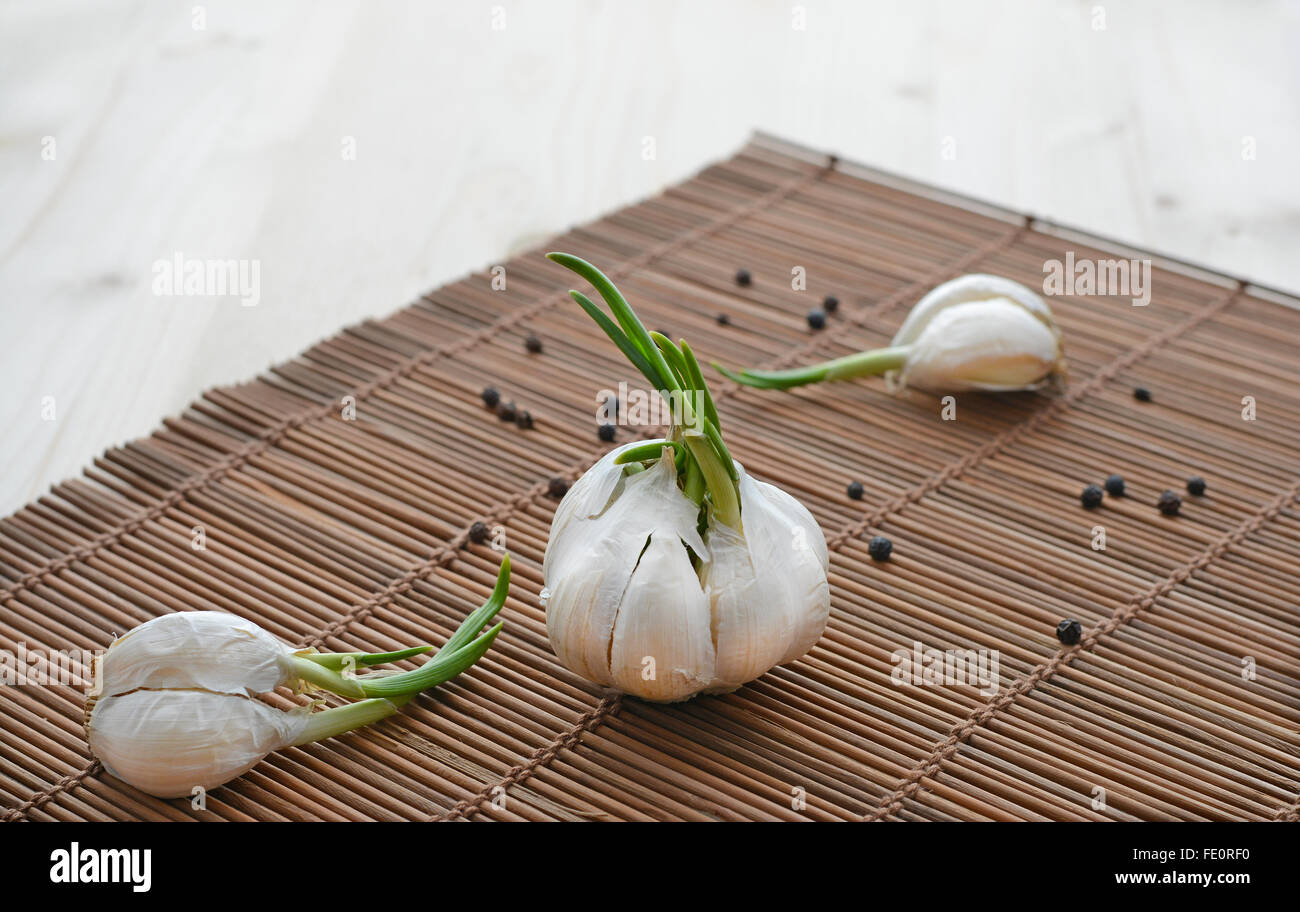 Spices - garlic bulb with green leafs and pepper Stock Photo - Alamy